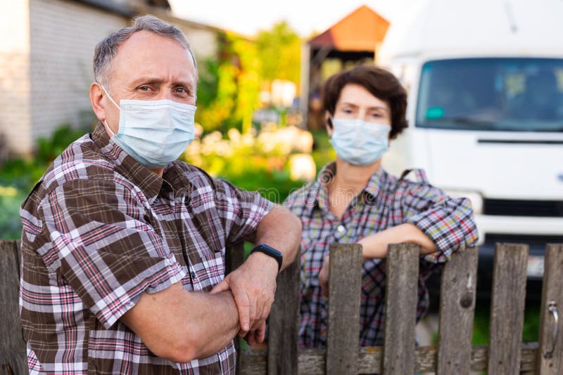 Farm Neighbors in Protective Masks Talk at the Border of Garden Plot ...