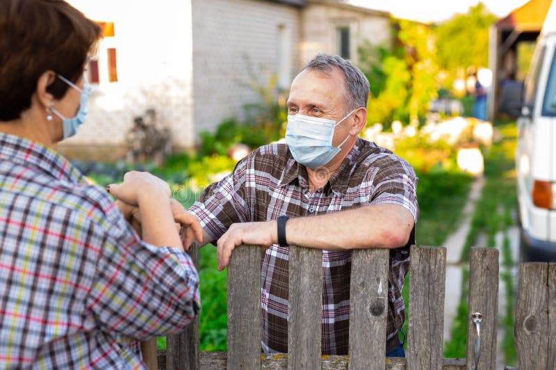 Farm Neighbors in Protective Masks Talk at the Border of Garden Plot ...