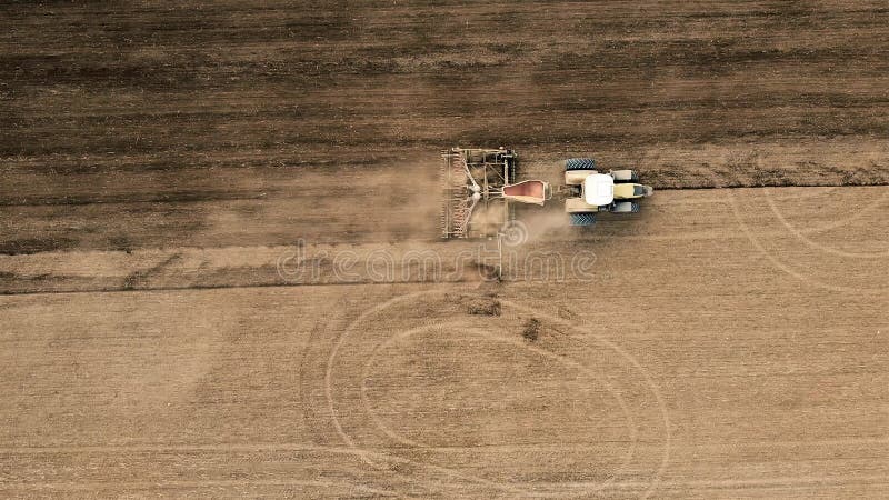 Sowing the Field with Corn Grains. Tractor Works the Field with a ...