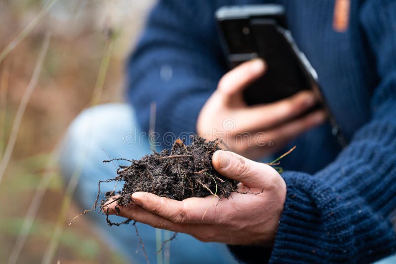 Farmer in Agriculture Looking at a Soil Sample, on a Farm Stock Photo ...