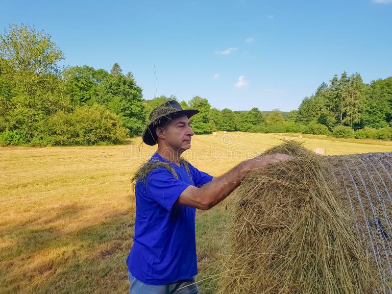 A Farmer in a Hat Stands at a Stack of Fresh Hay Stock Image - Image of ...