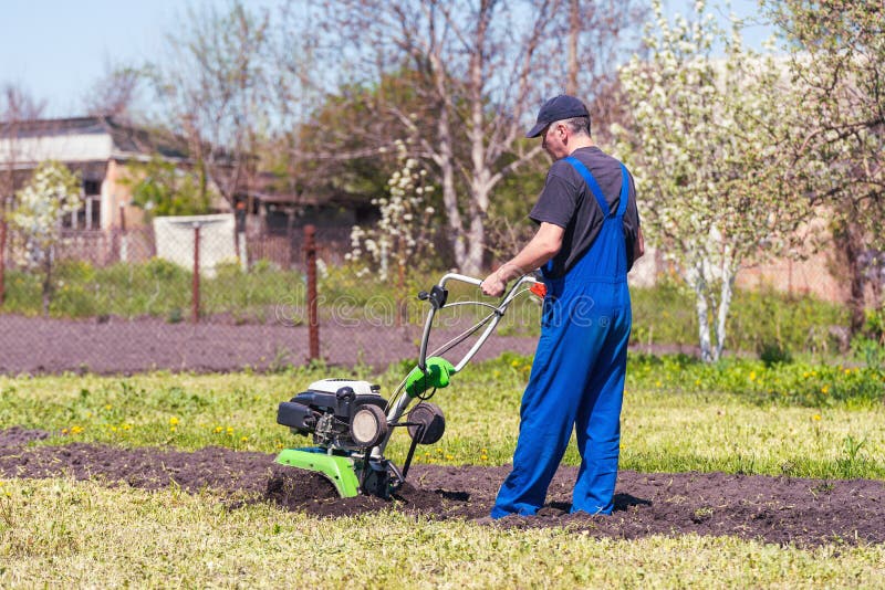 Farmer Man Plows the Land with a Cultivator Preparing the Soil for ...