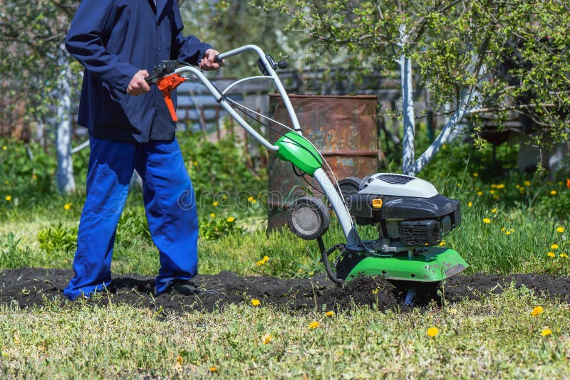 Farmer Man Plows the Land with a Cultivator Preparing the Soil for ...