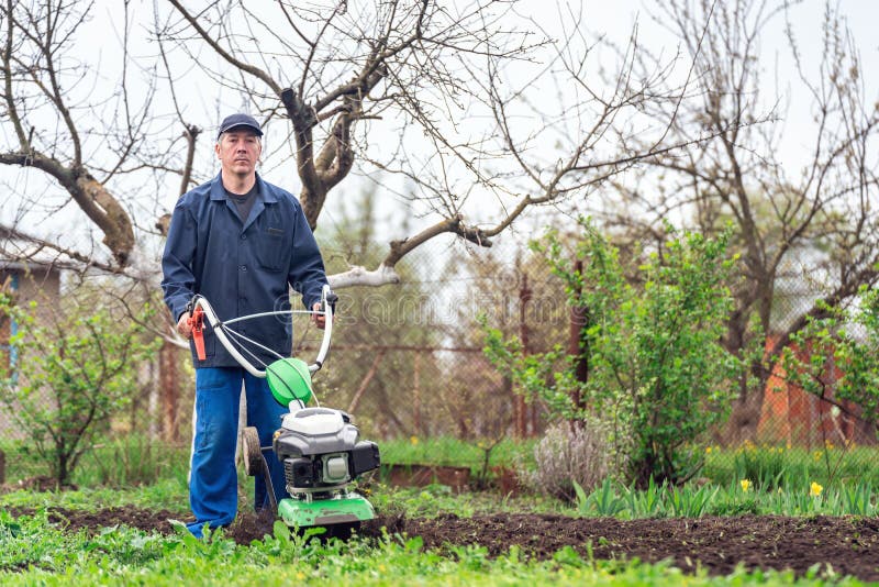 Farmer Man Plows the Land with a Cultivator Preparing the Soil for ...