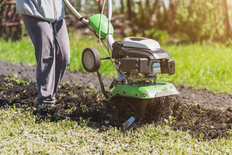 Farmer Man Plows the Land with a Cultivator Preparing the Soil for ...