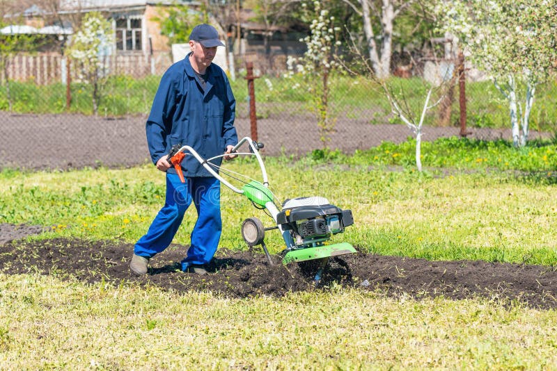 Farmer Man Plows the Land with a Cultivator Preparing the Soil for ...