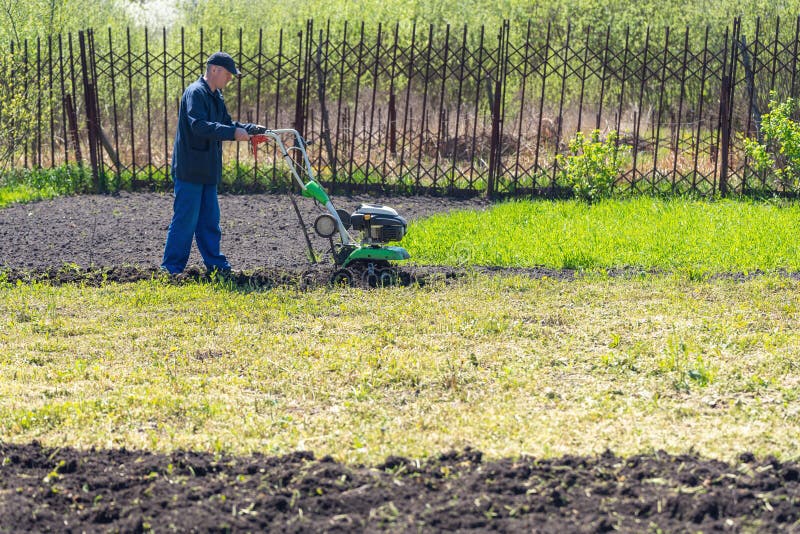 Farmer Man Plows the Land with a Cultivator Preparing the Soil for ...