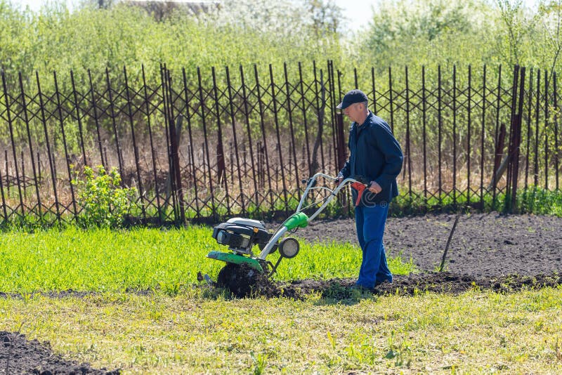 Farmer Man Plows the Land with a Cultivator Preparing the Soil for ...