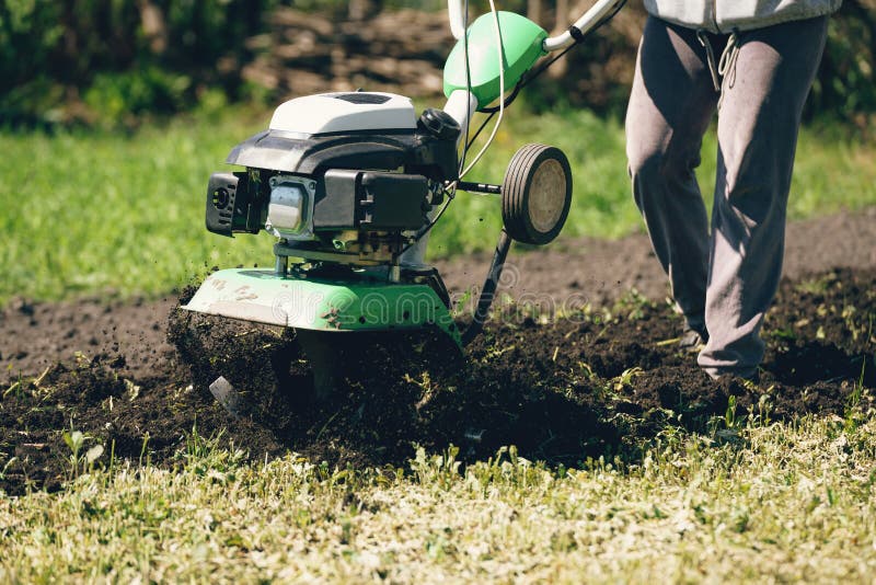 Farmer Man Plows the Land with a Cultivator Preparing the Soil for ...