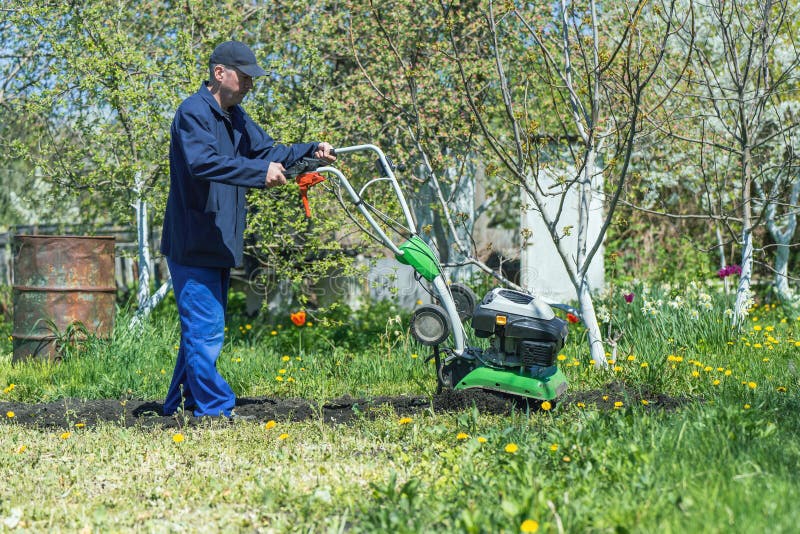 Farmer Man Plows the Land with a Cultivator Preparing the Soil for ...