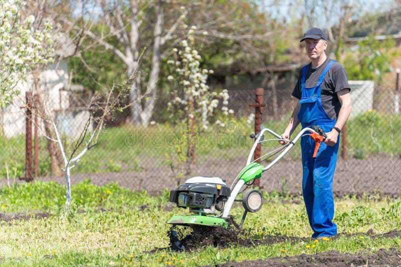 Farmer Man Plows the Land with a Cultivator Preparing the Soil for ...