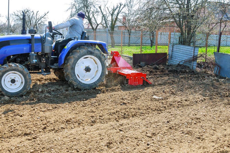 A Farmer Plows the Soil in the Field with a Chisel Plow on a Tractor ...