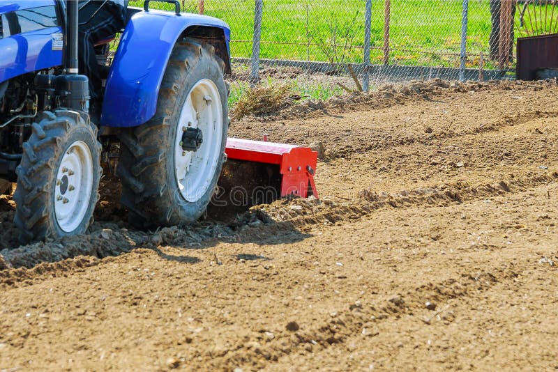 Farmer Plows the Field. Small Tractor with a Plow in the Field ...