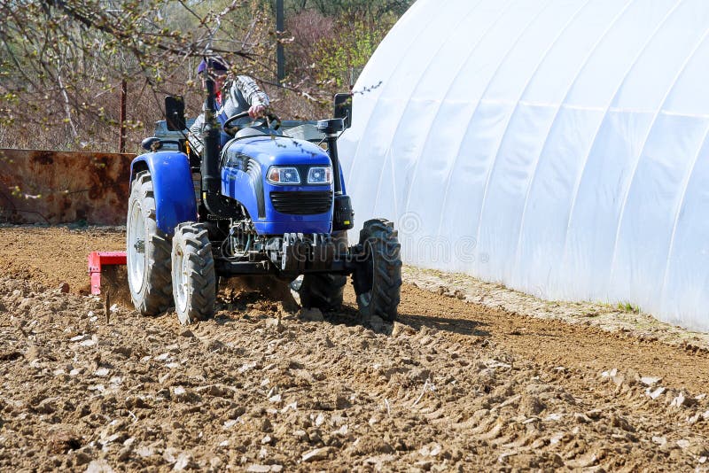 A Farmer Plows the Soil in the Field with a Chisel Plow on a Tractor ...