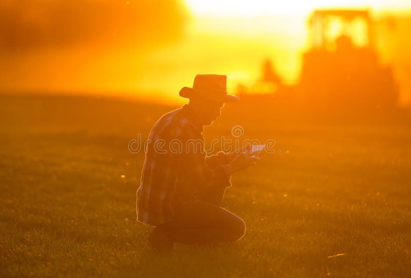 Farmer with Tablet Squatting in Front of Tractor Stock Photo - Image of ...