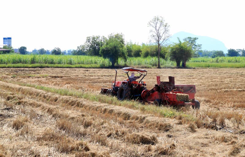 Farmer and Tractor Packing Straw Stock Photo - Image of grass, bale ...