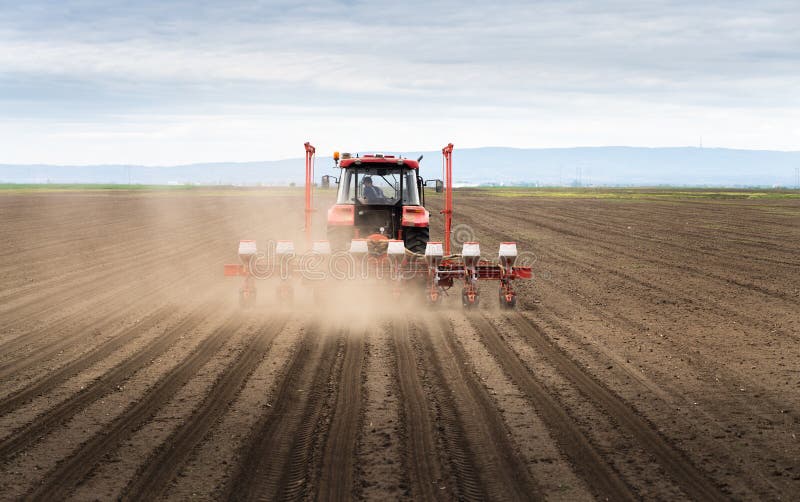Farmer with Tractor Seeding - Sowing Crops at Agricultural Field Stock ...