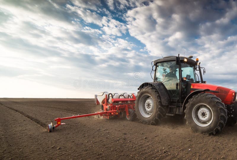 Farmer with Tractor Seeding - Sowing Crops at Agricultural Field Stock ...