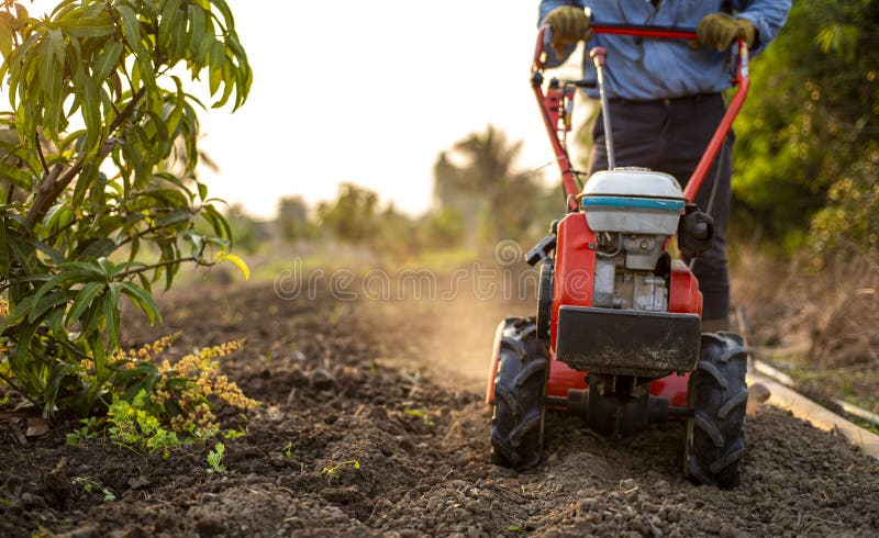 Farmer Using Rotary Tiller on a Plowed Field at Dawn Stock Photo ...