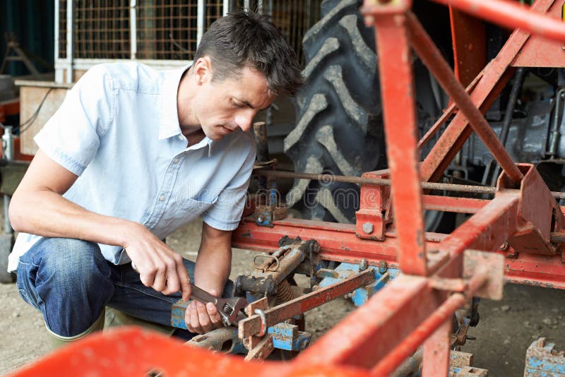 Farmer Working on Agricultural Equipment in Barn Stock Image - Image of ...