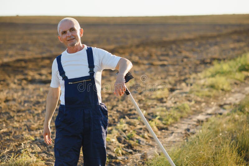 A farmer works with a rake stock photo. Image of country - 190753752