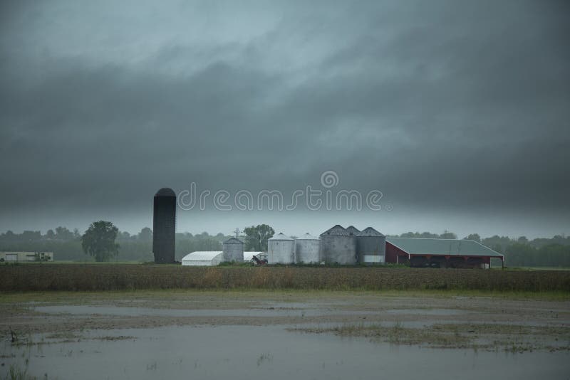 Farmland with Industrial Buildings Under the Dark Cloudy Dramatic Sky ...