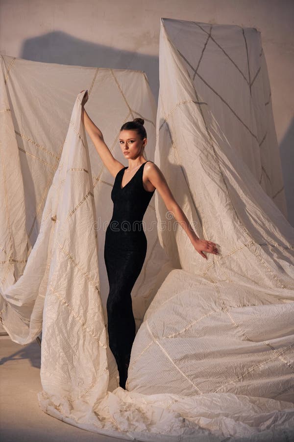 Fashion Model Showcases Elegance while Holding Draped Fabric in a ...