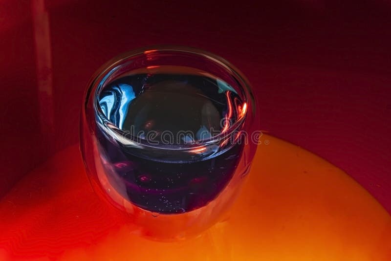 Fashionable Double Bottom Cup with Blue Liquid on Red Backround ...