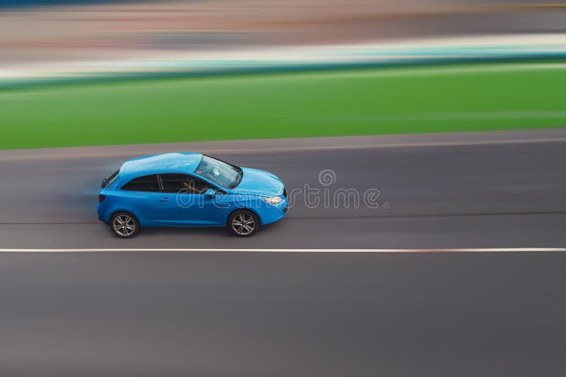 Fast Car. a Small Blue Car is Driving at High Speed on the Highway with ...