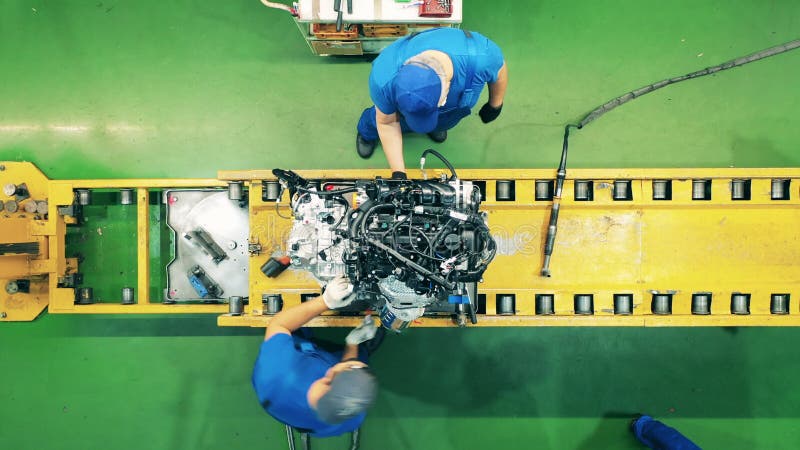 Fast Motion of Technicians Assembling a Car Engine in a Top View Stock ...