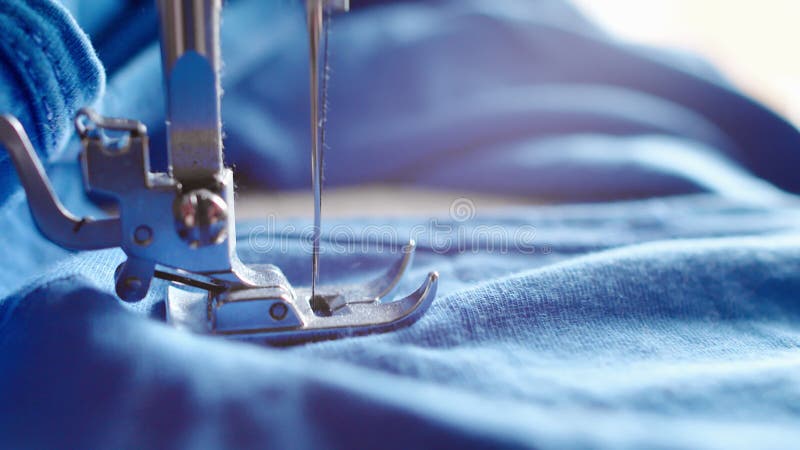 Fast Movement of the Sewing Machine Needle on the Blue Fabric. the ...