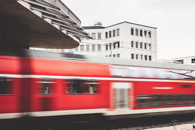 Fast Moving Red Train at a Railway Station with White Buildings in the ...