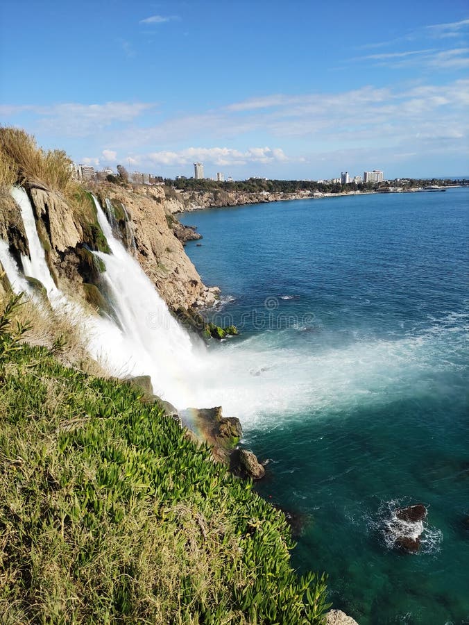 A Fast Waterfall Falling from Mountain Cliff into the Blue Sea Stock ...