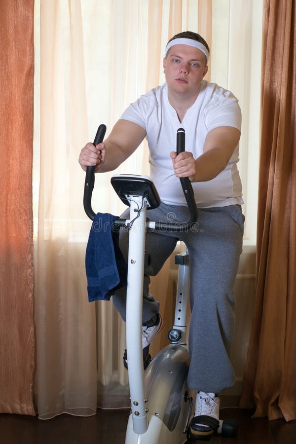 Fat Guy Exercising on Stationary Training Bicycle Stock Photo - Image ...