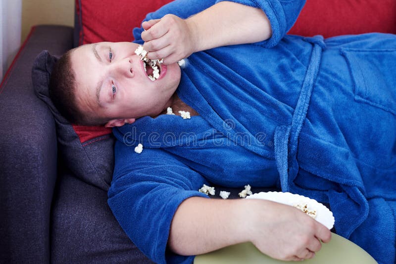 Fat Man in a Robe Eating Popcorn while Sitting on the Couch Stock Image ...