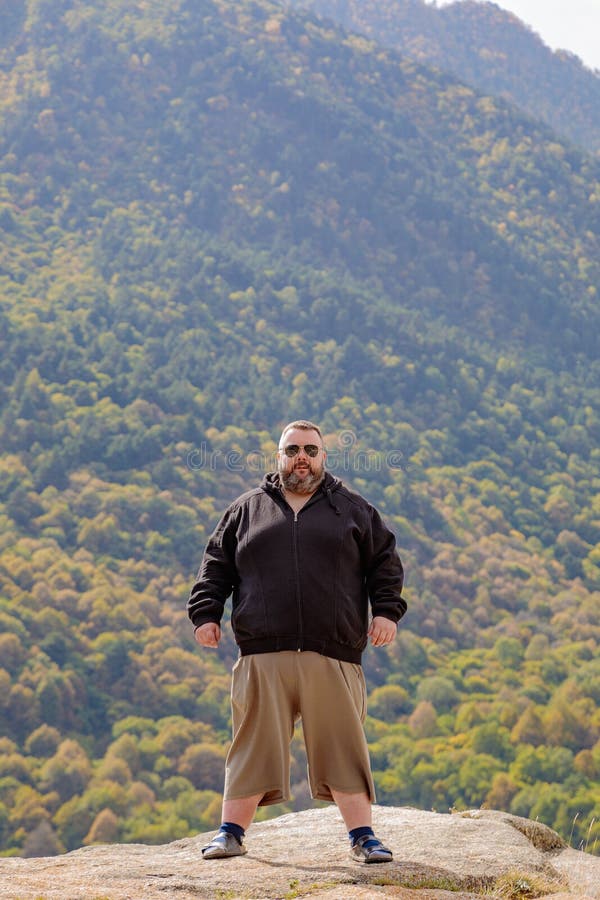 The Fat Man Stands on the Top of the Mountain. Stock Photo - Image of ...