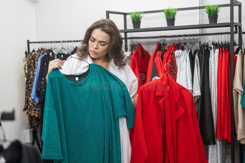 A Fat Woman Chooses Clothes by Comparing Them in a Plus Size Store ...