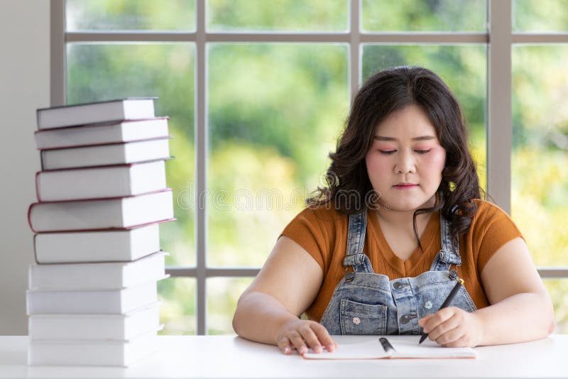 Fat Woman Student with Concentration Sitting and Holding Pen Writing on ...