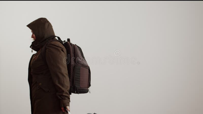 A Fat Woman in a Warm Jacket with a Hood with a Backpack and a Suitcase ...