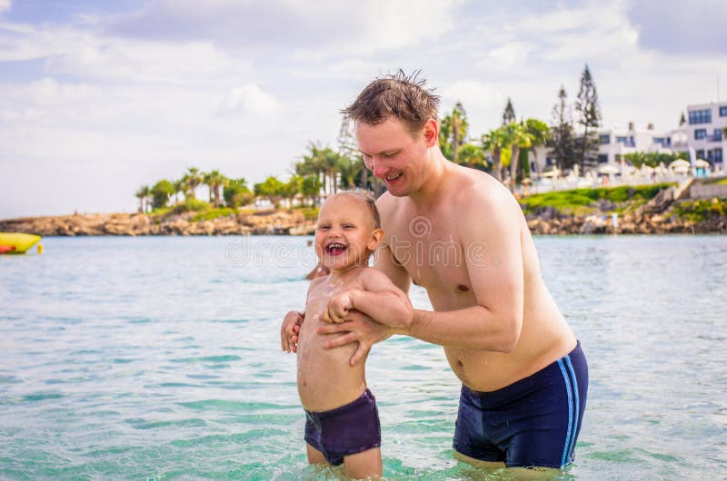The Father Bathes His Young Son in the Sea Stock Photo - Image of ...