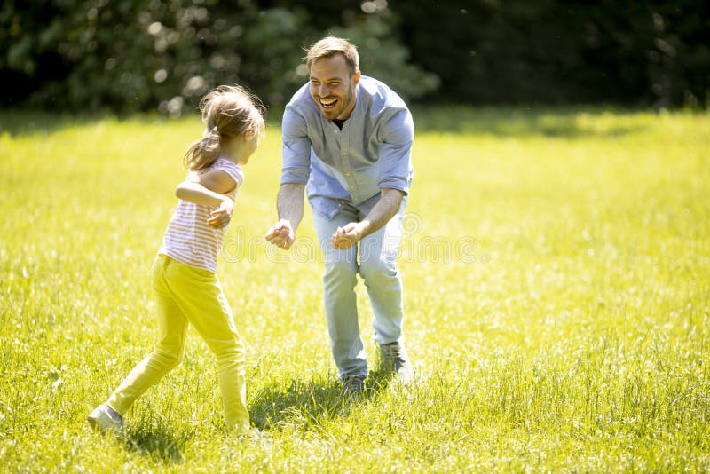 Father Chasing His Little Daughter while Playing in the Park Stock ...