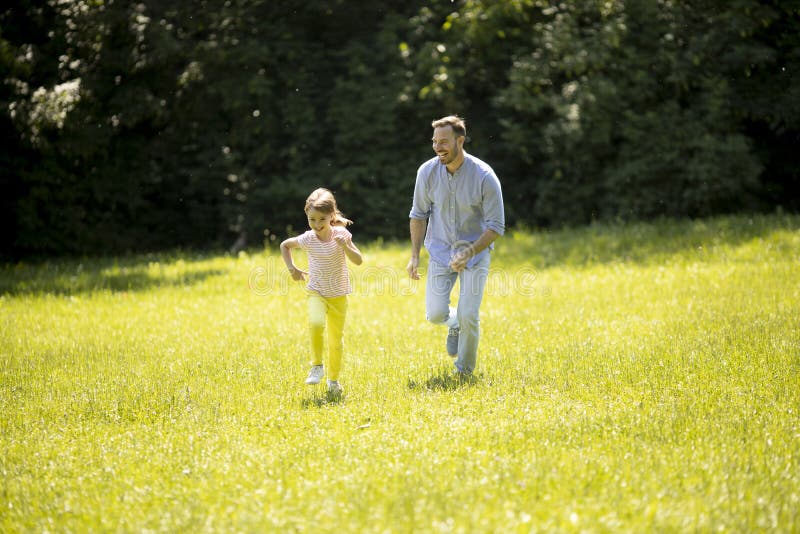 Father Chasing His Little Daughter while Playing in the Park Stock ...