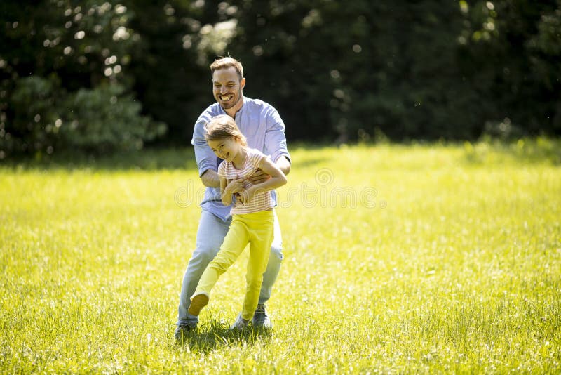 Father Chasing His Little Daughter while Playing in the Park Stock ...