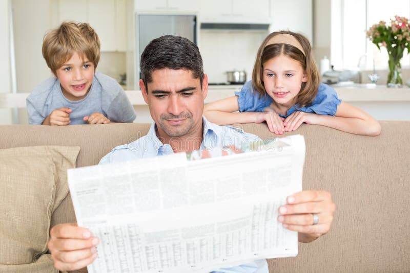 Father Reading Newspaper, Daughter Watching TV Stock Photo - Image of ...