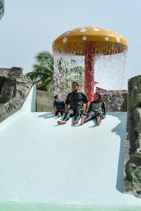 Father and Children Sliding into Pool after Going Down Water Slide ...