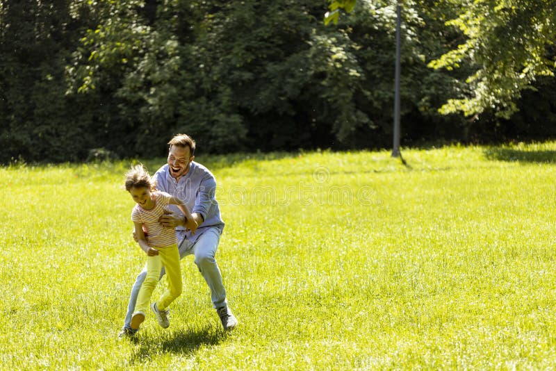 Father with Daughter Having Fun on the Grass at the Park Stock Photo ...