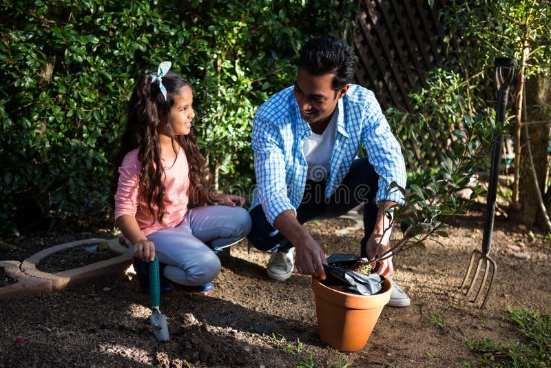 Father and Daughter Potting a Plant in Pot at Backyard Stock Image ...