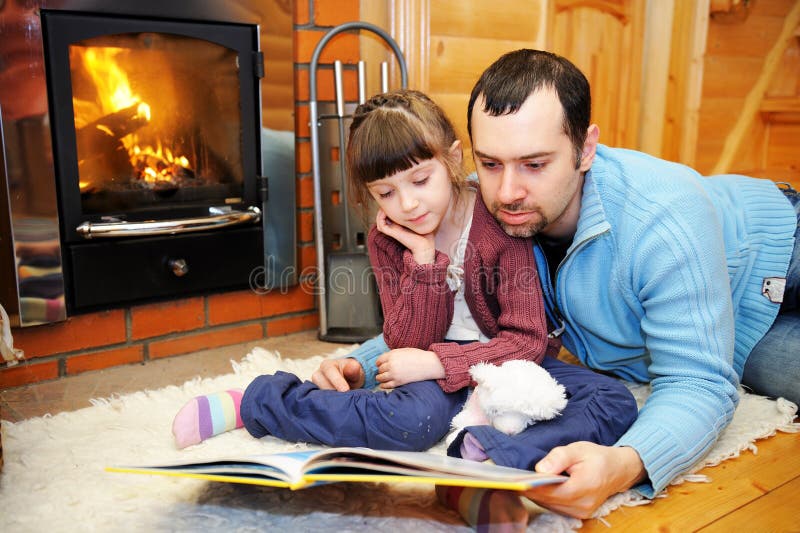 Father and Daughter Reading in Front of Fireplace Stock Photo - Image ...