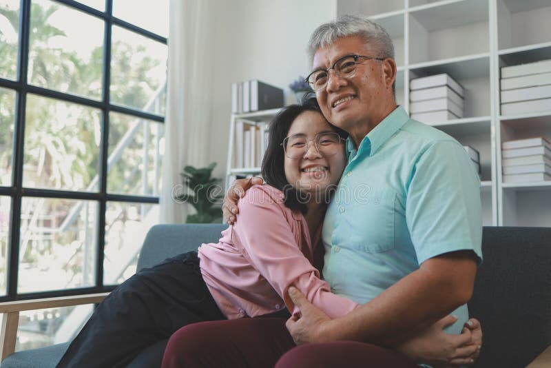 A Father And Daughter Sat In The Living Room Happily Spending Time