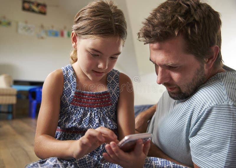Father and Daughter Using Mobile Phone in Playroom Together Stock Photo ...